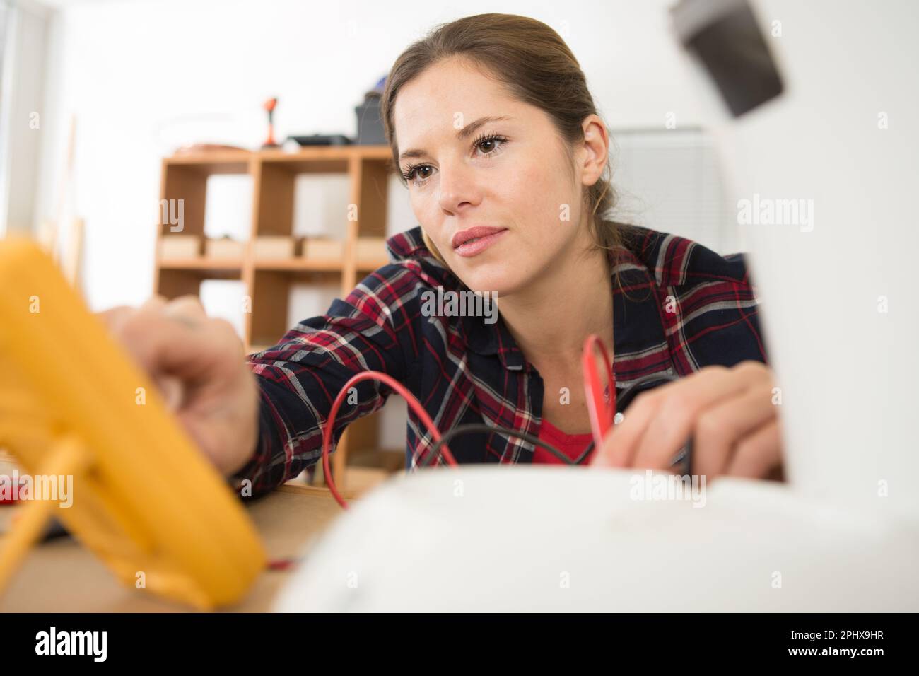 female technician using multimeter to test appliance Stock Photo - Alamy