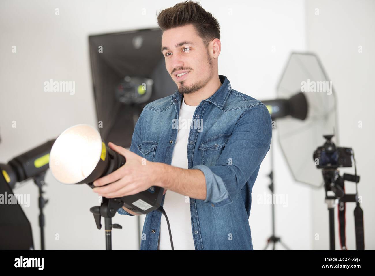 photographer preparing studio with spot lamps Stock Photo - Alamy