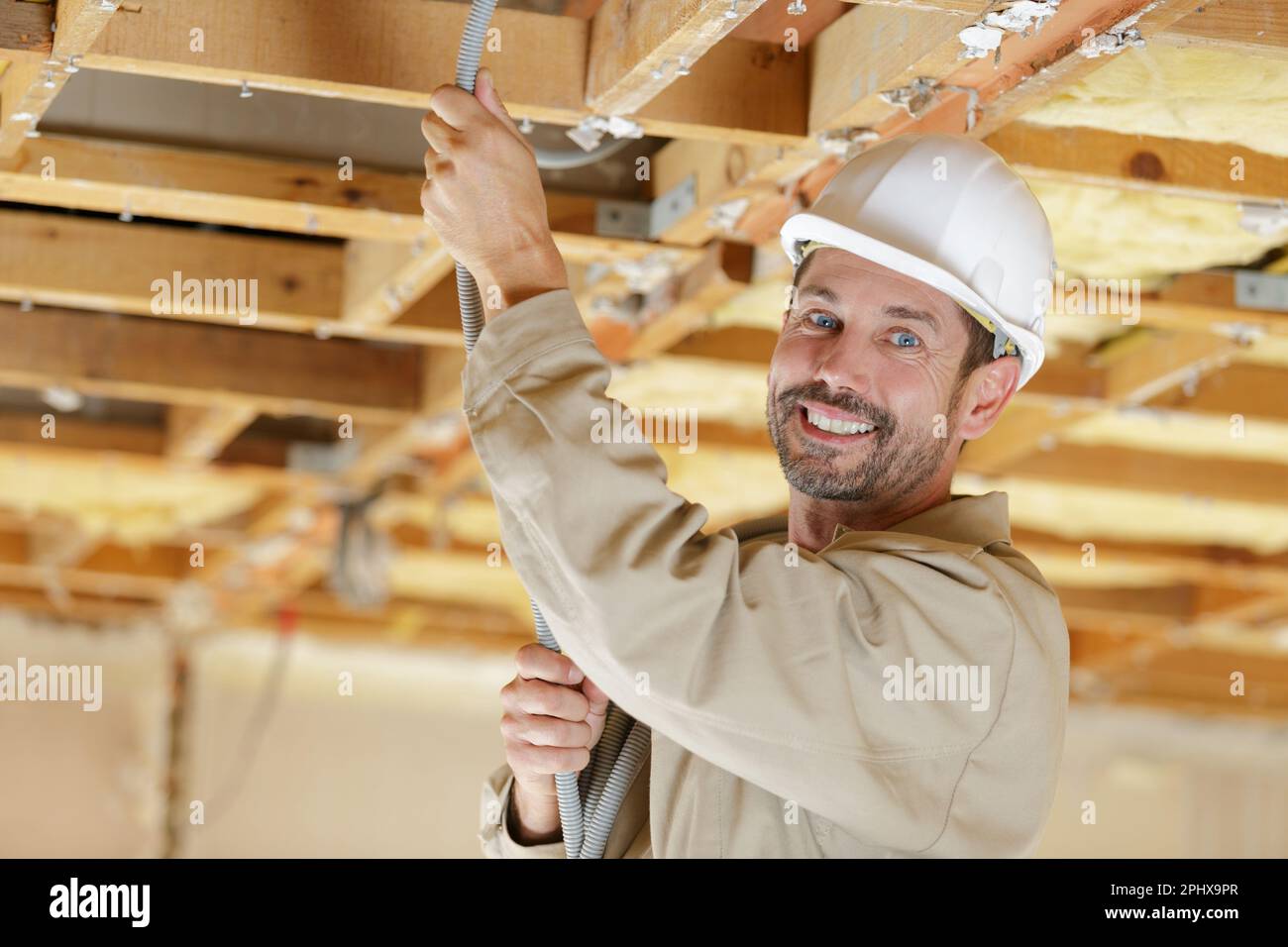 builder passing wires in wood structure Stock Photo - Alamy