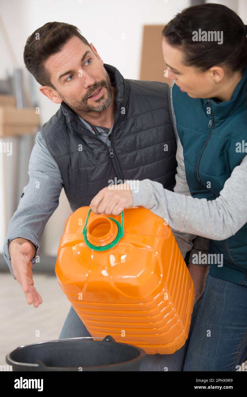 workers in discussion while pouring product into bucket Stock Photo - Alamy