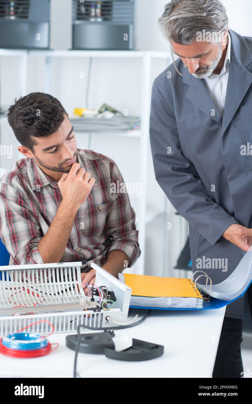 two people fixing a radiator Stock Photo - Alamy