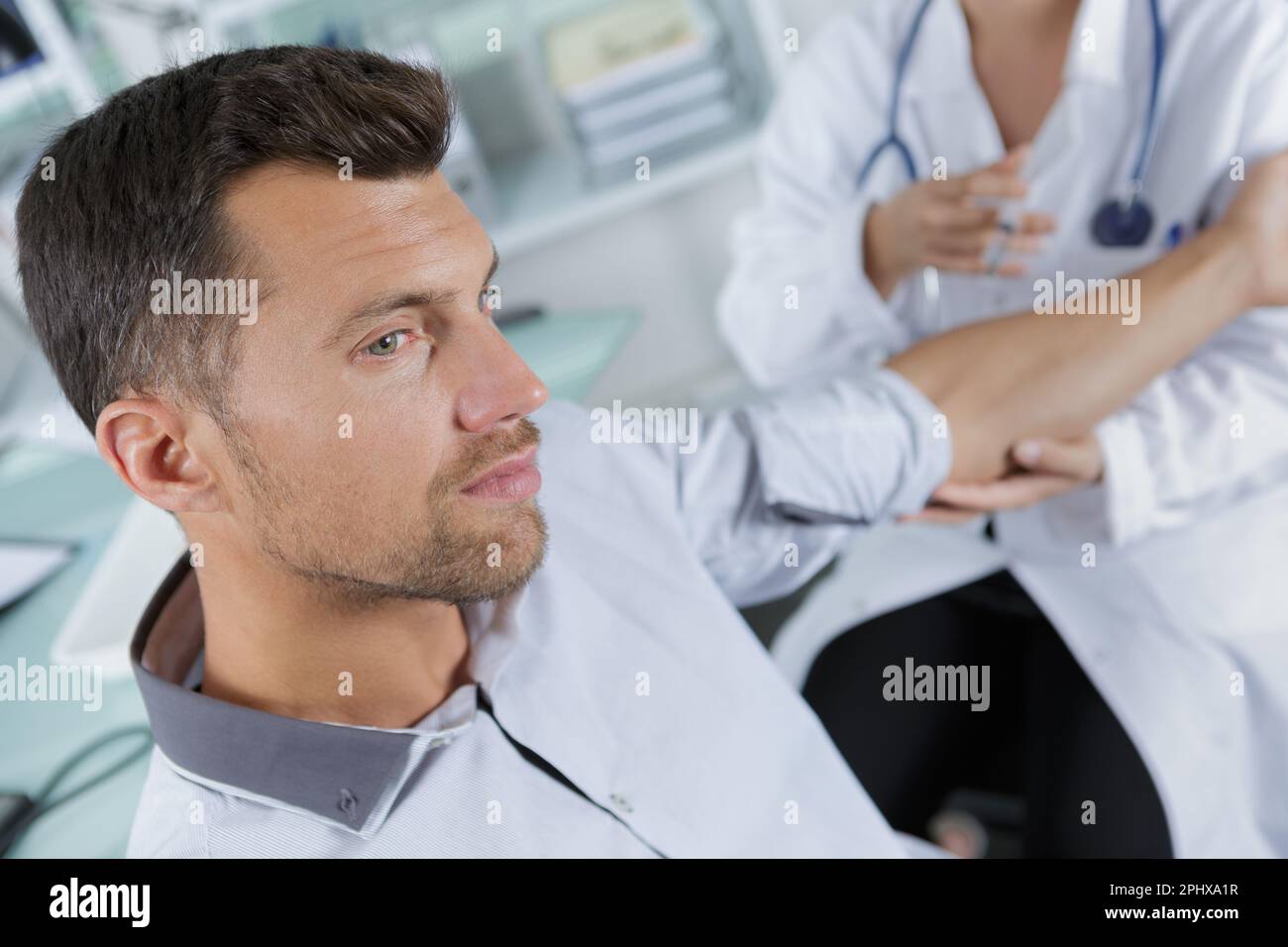 man looking away as doctor prepares to inject him Stock Photo - Alamy
