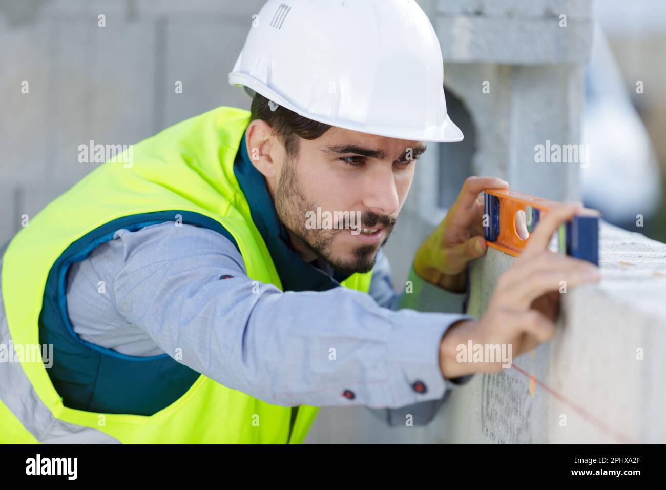 man bricklayer is measurement level Stock Photo - Alamy