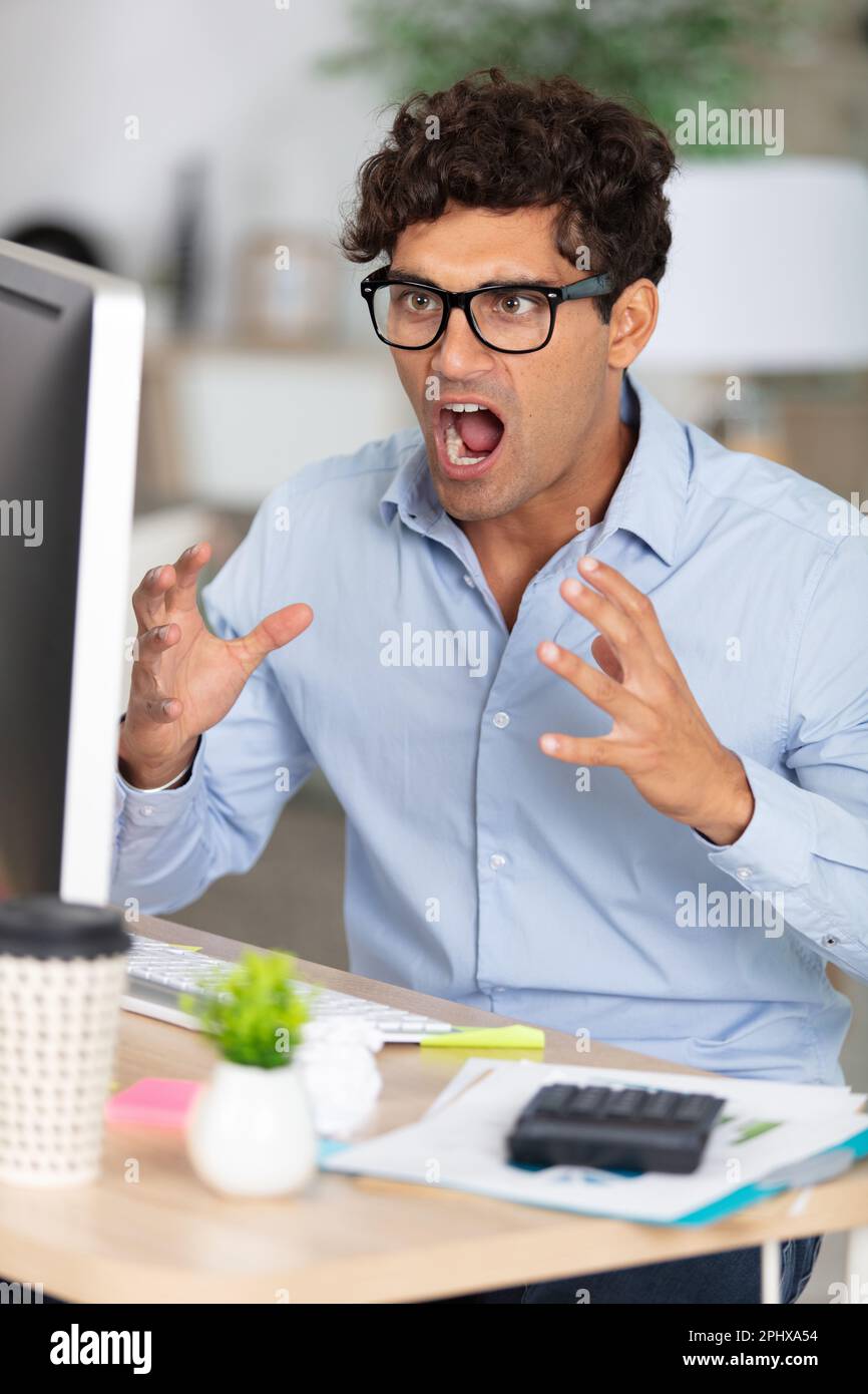 angry and furious at computer in a little office Stock Photo - Alamy