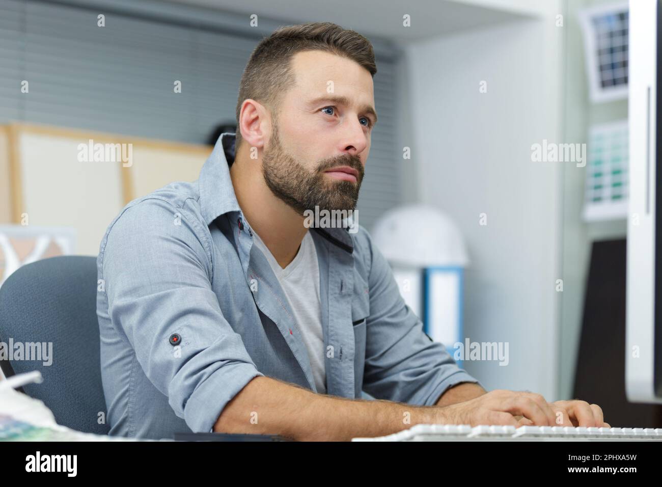 man using a computer in an office Stock Photo - Alamy