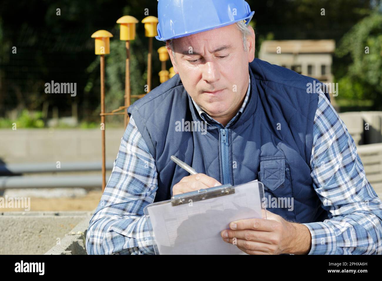 mature construction manager writing report at construction site Stock ...