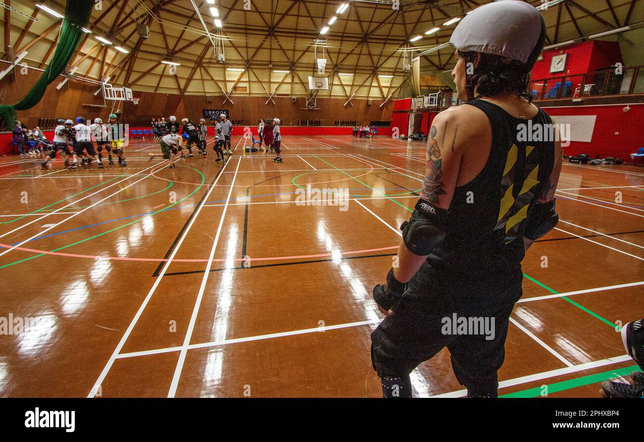 A roller derby skater stands in the penalty box showing that he is ...