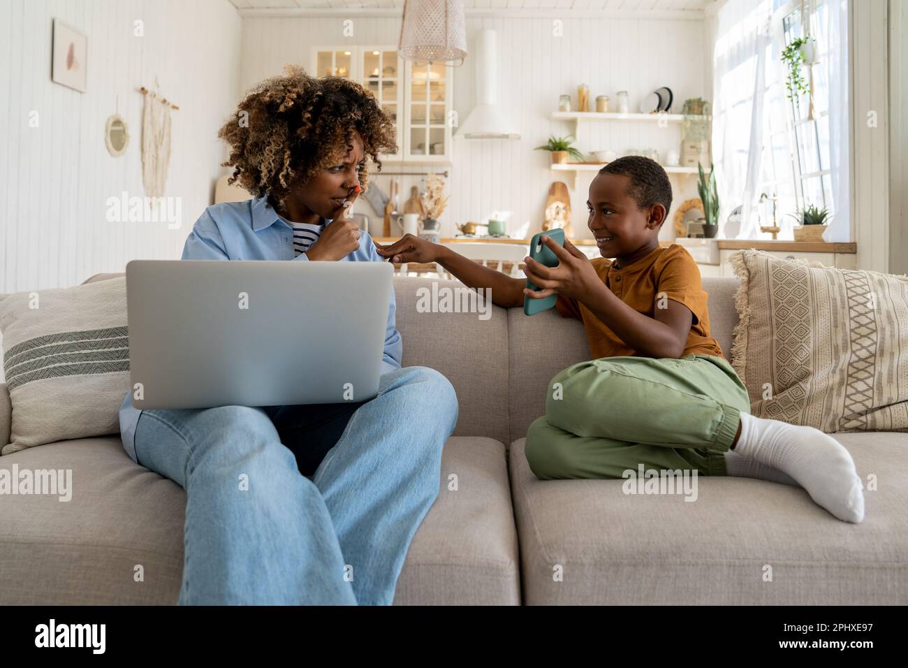 African American boy kid asking attention from busy mother freelancer ...