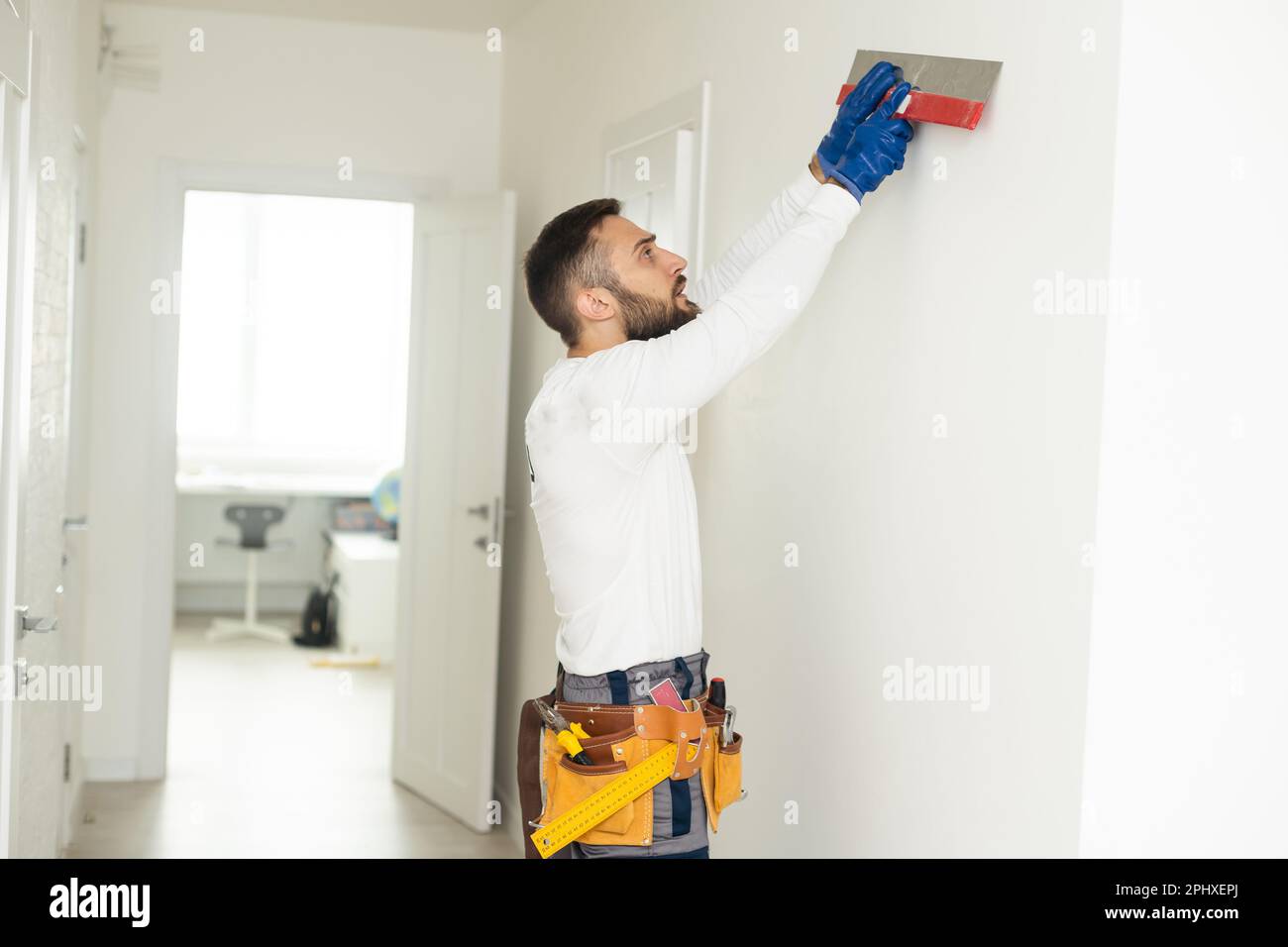 man plasterer construction worker at work, takes plaster from bucket ...
