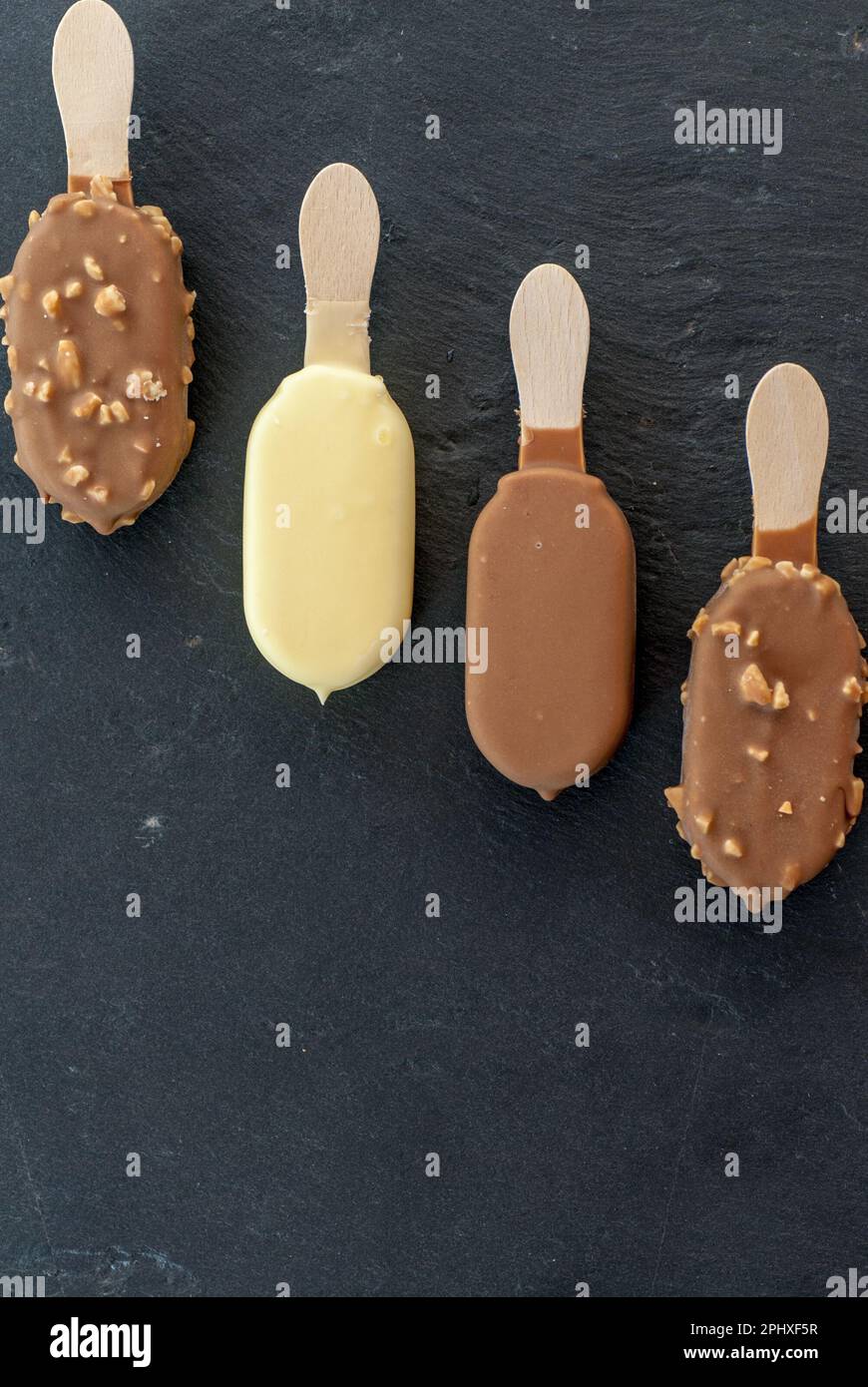 assorted mini ice creams on stick on black Stock Photo - Alamy