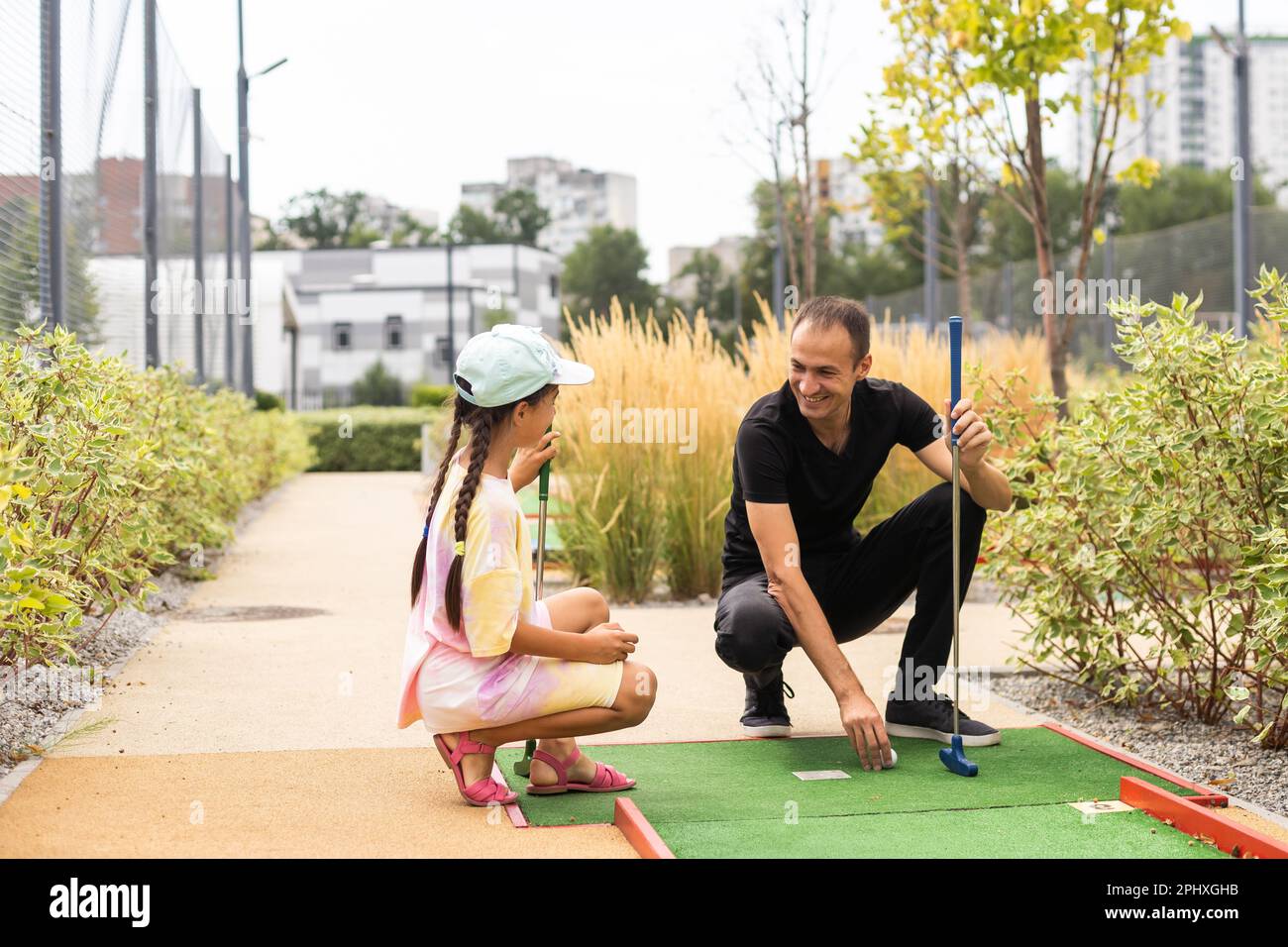 Family: Family Time Playing Mini-Golf In The Summer Stock Photo - Alamy