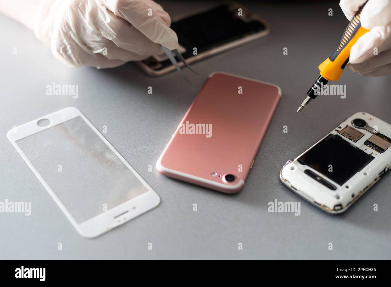 The technician repairing the smartphone's motherboard in the lab with ...