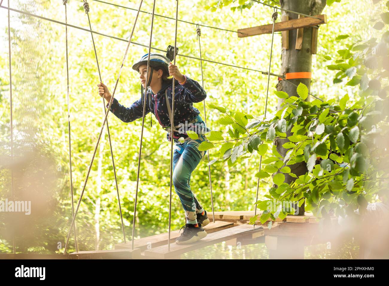 Little girl preschooler wearing full climbing harness having fun time ...