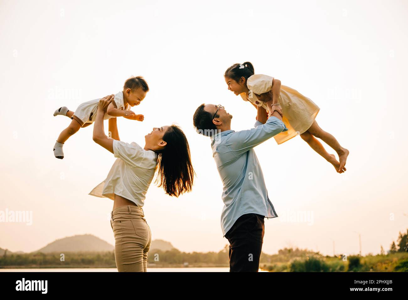 A happy family enjoys a playful moment in a summer field Stock Photo ...