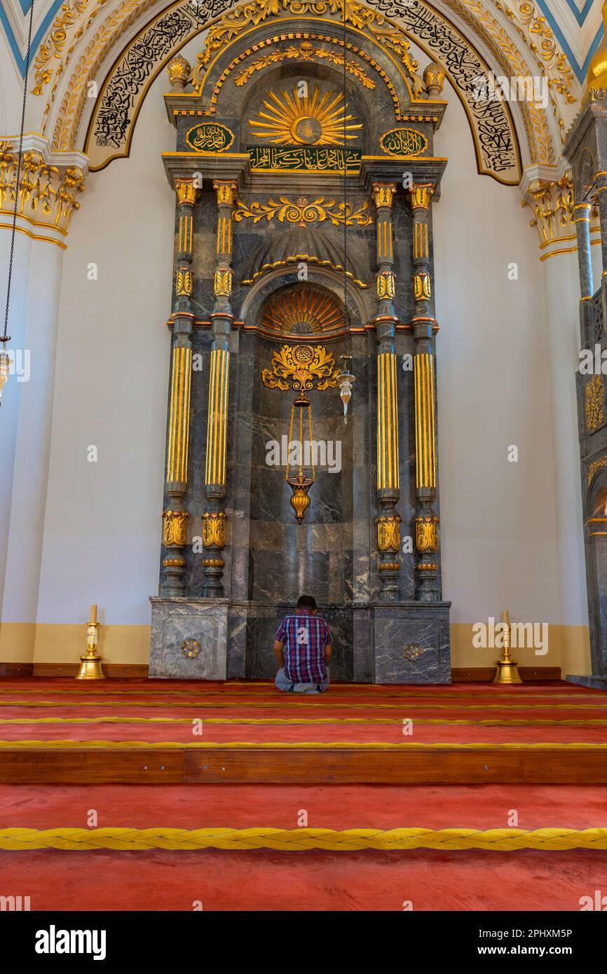 Muslim man praying in front of the mihrab of Aziziye Mosque. Ottoman ...