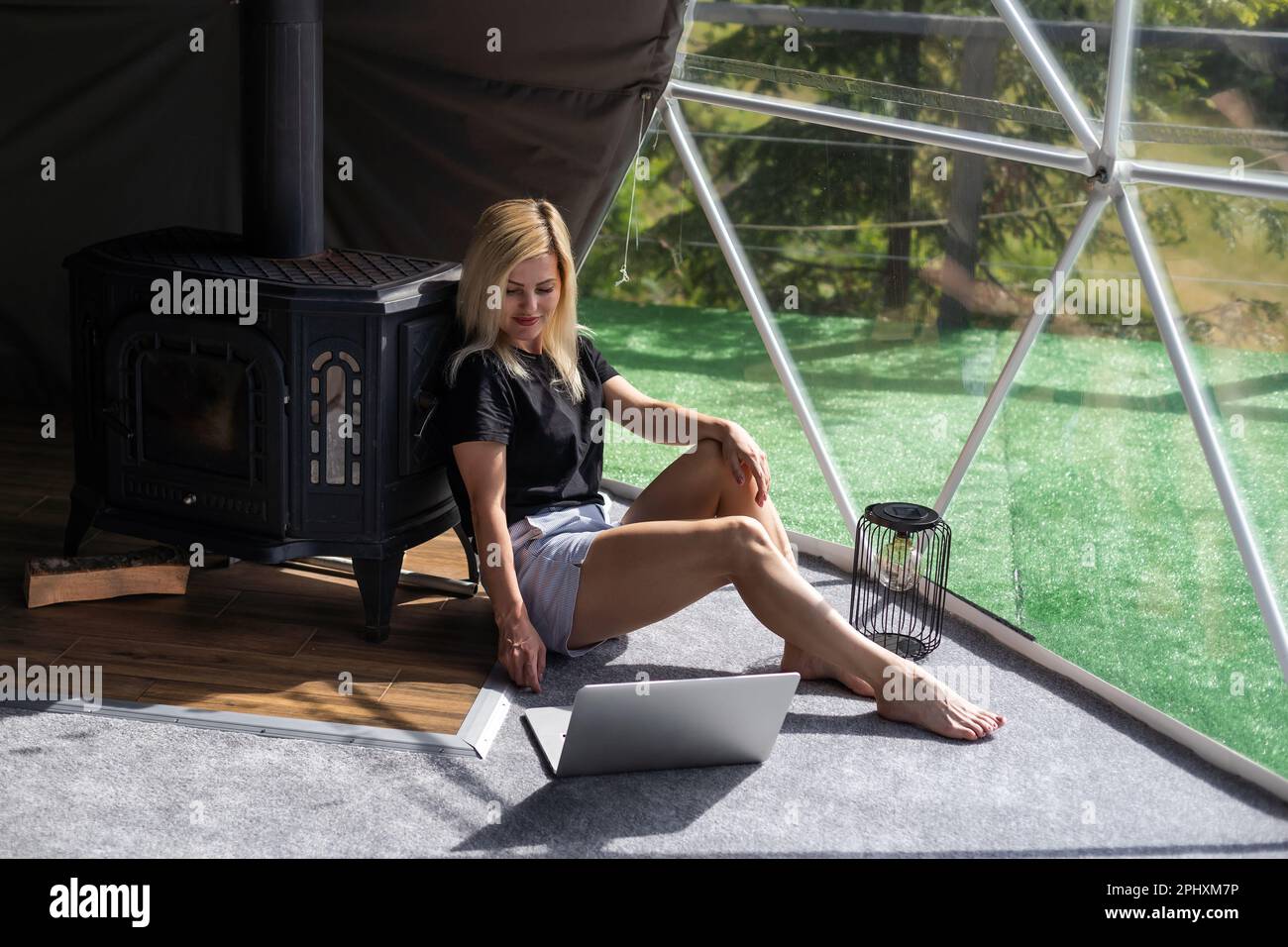 Woman working on laptop geo dome tents. Green, blue background. Cozy, camping, glamping, holiday ...