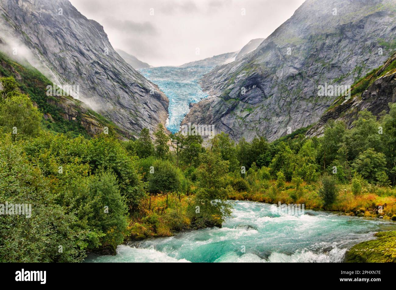 ice waterfall in a glacier in Norway with Rocky Mountains an lake from ...