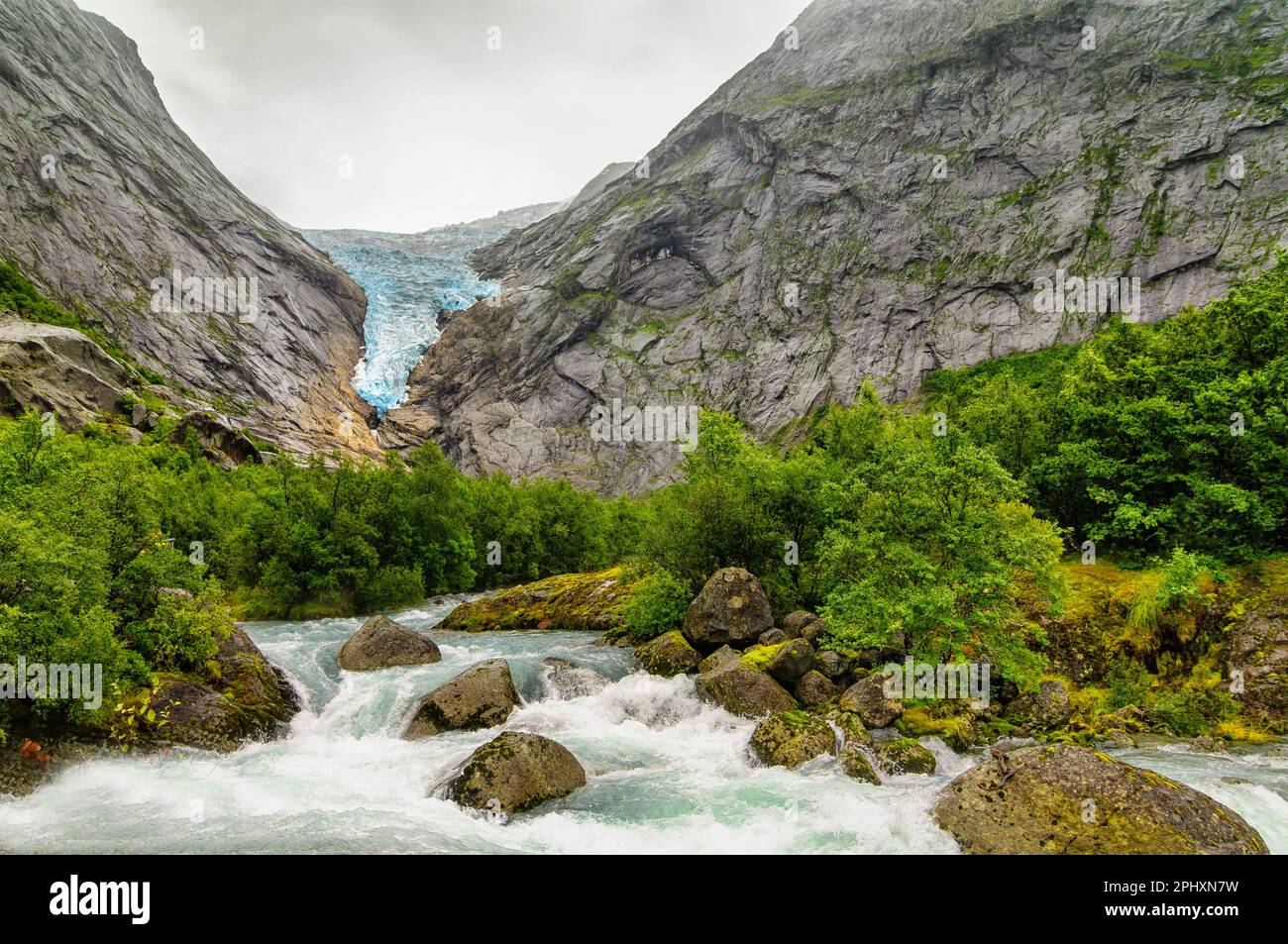 ice waterfall in a glacier in Norway with Rocky Mountains an lake from ...