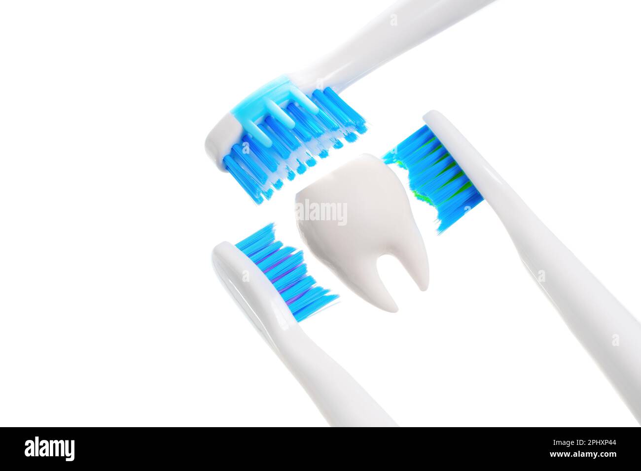 Close-up view of three electric toothbrushes framing a tooth model ...