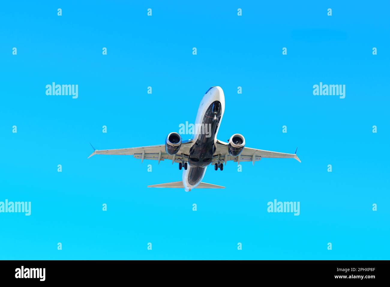 Landing aircraft's underbelly in full view against a clear blue sky ...