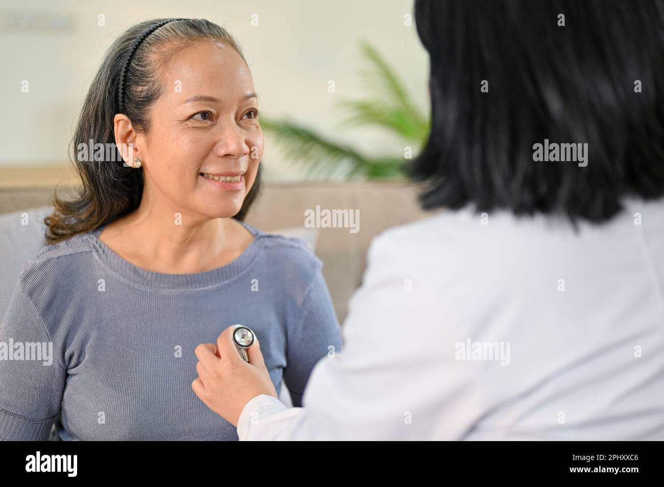 Happy and attractive senior Asian woman is having her heart and lungs ...