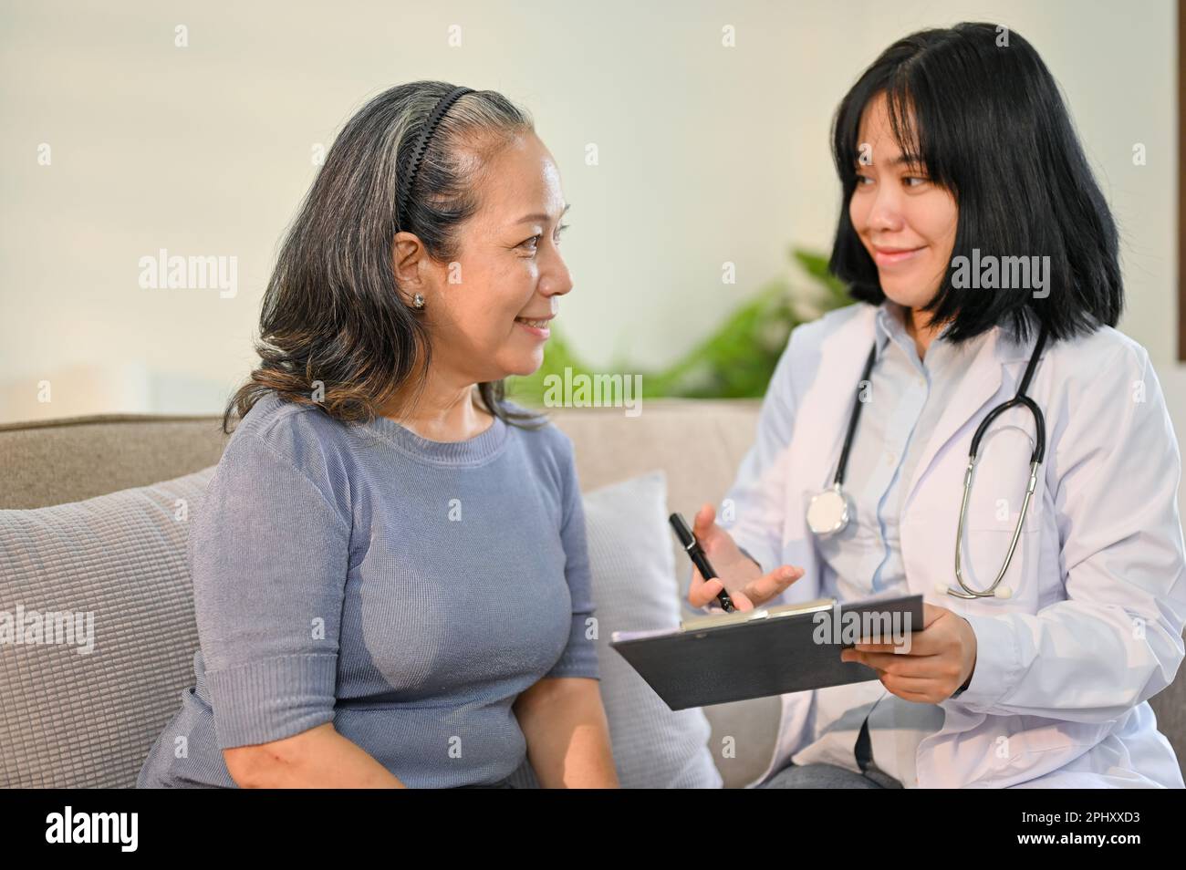 Attractive senior Asian woman is being diagnosed and discussing her medical treatment plan with ...