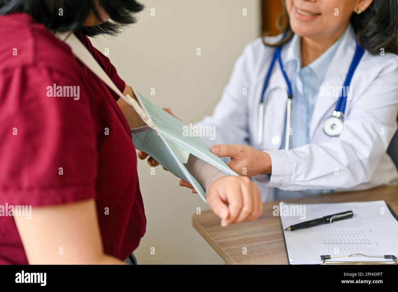 Close-up image of a female patient with a broken arm is being checked ...