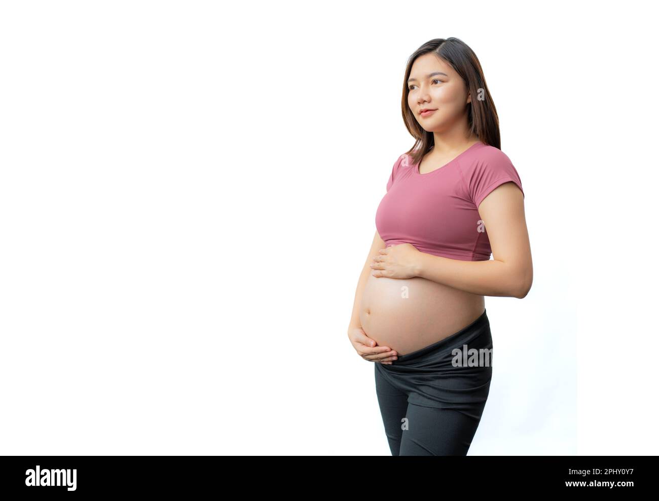 Happy smiling Asian pregnant woman in fitness clothes standing holding ...
