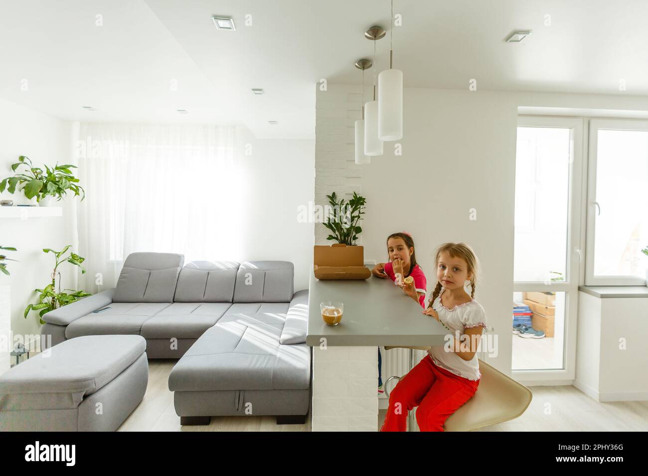 Two little girls eating curd and chatting Stock Photo - Alamy