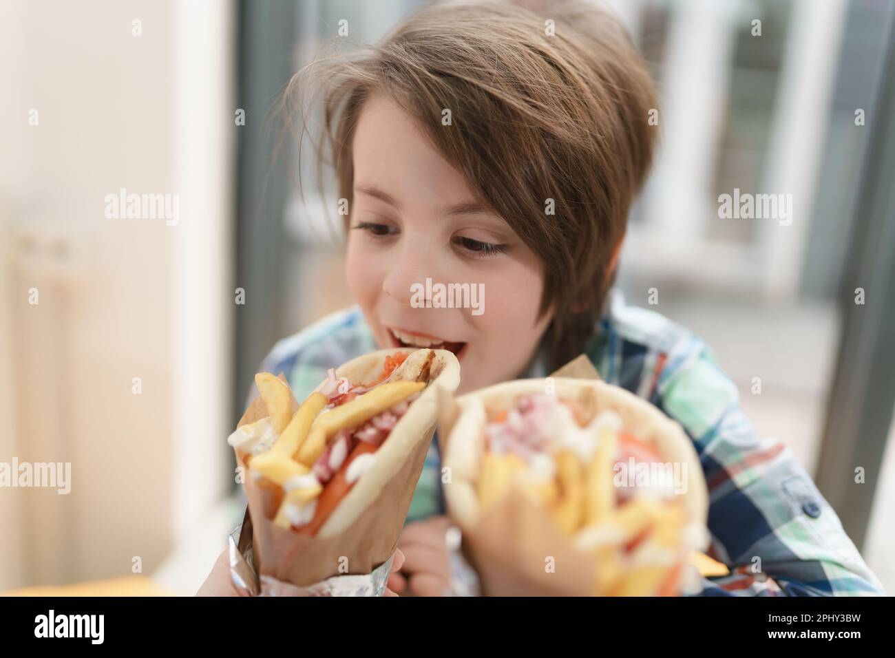 Cute little boy biting gyro sandwich. Handsome young kid eating ...