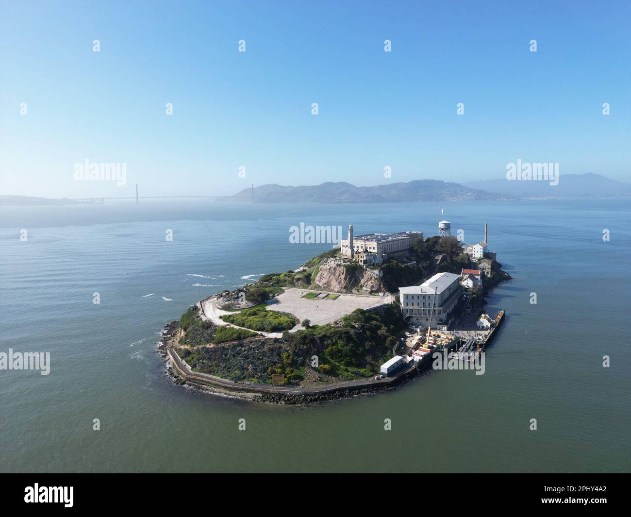 A drone view of the Alcatraz Island under a blue sky and sunlight in ...