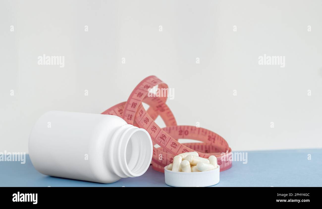 white pills bottle with vitamin c capsules with stethoscope and measure ...
