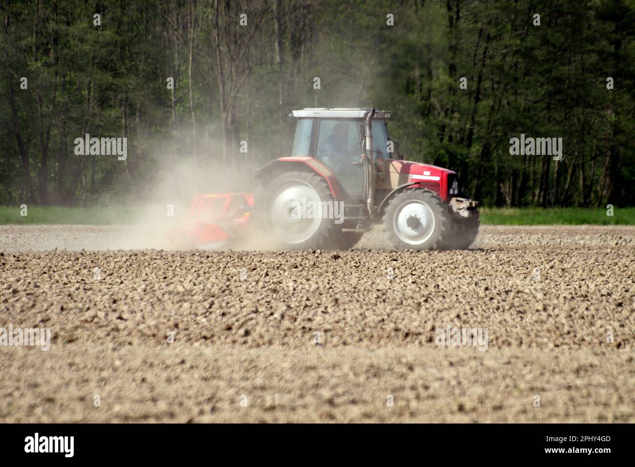 tractor in a field working the soil in a cloud of dust, Germany Stock ...