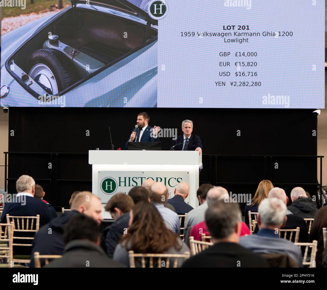 Mathew Priddy and Edward Rising, on the rostrum, during a live auction ...