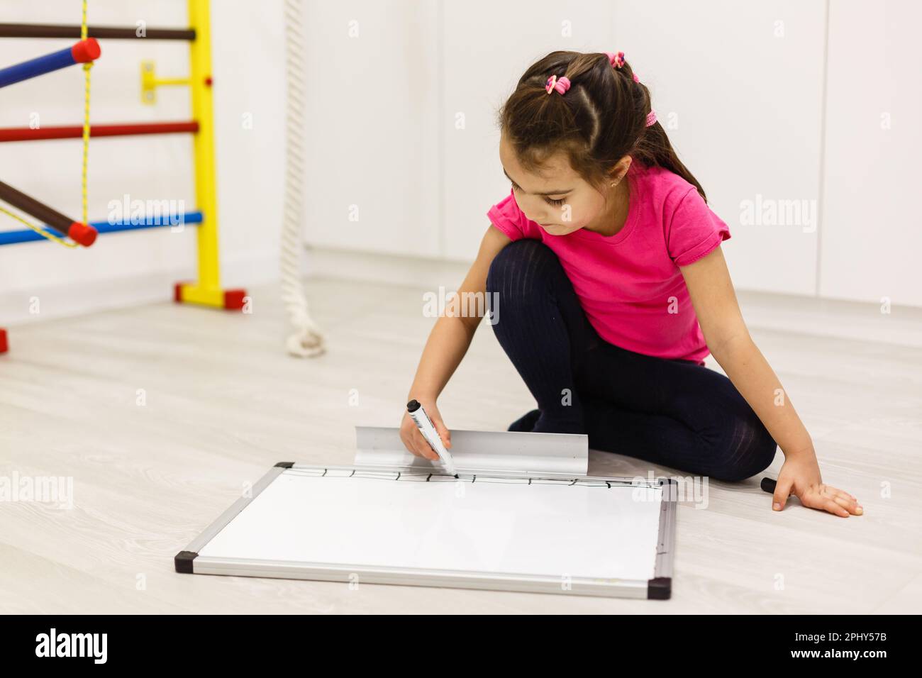Image of happy little girl sitting near a lot of colouring pencils over ...