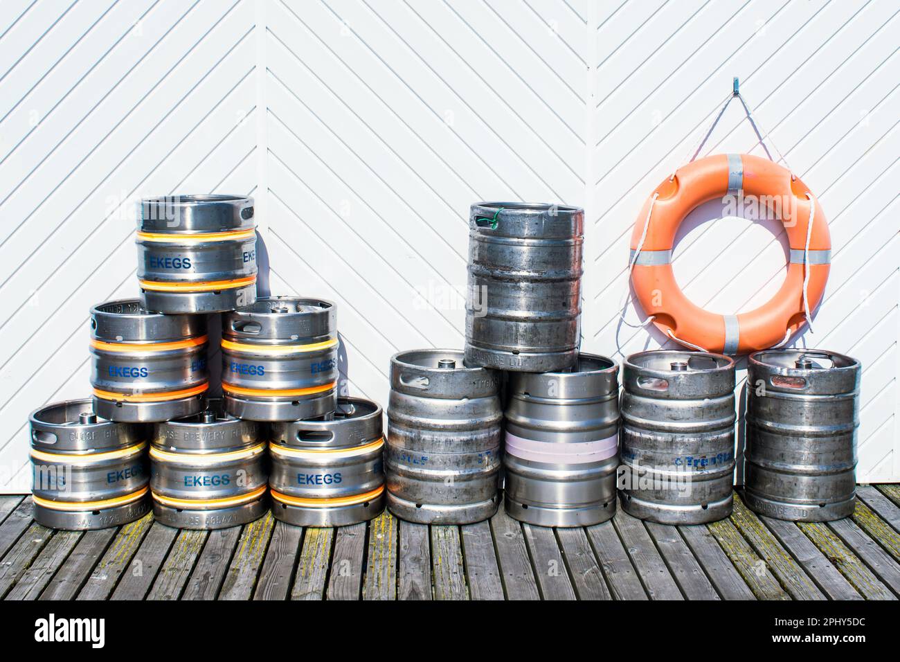 Close up of beer barrels and kegs against white wall on decking Stock ...