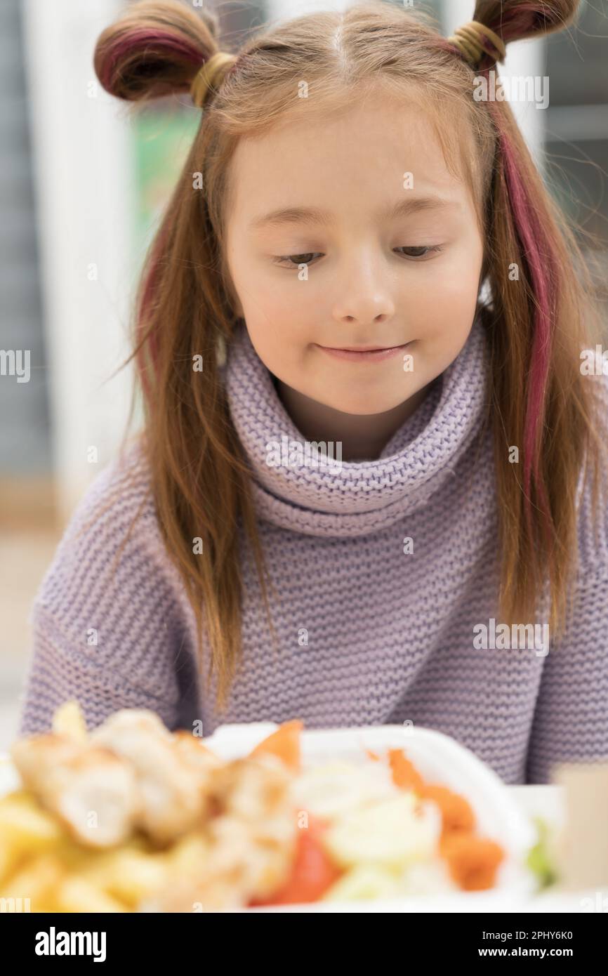 Hungry little girl looking at food on the table. Portrait of adorable ...