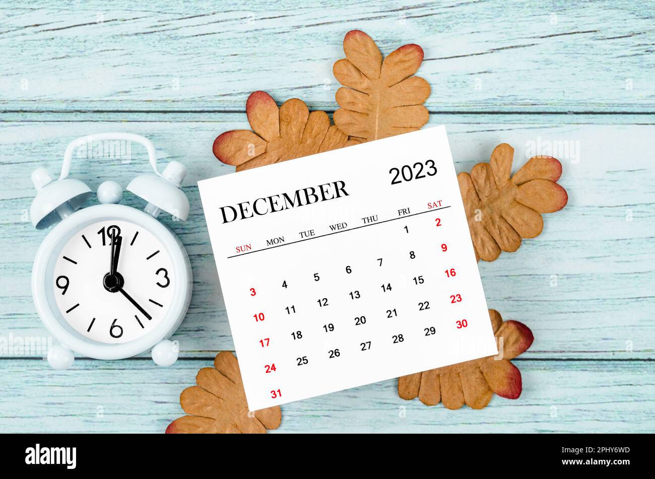 December 2023 Monthly calendar year and alarm clock with dried leaves ...