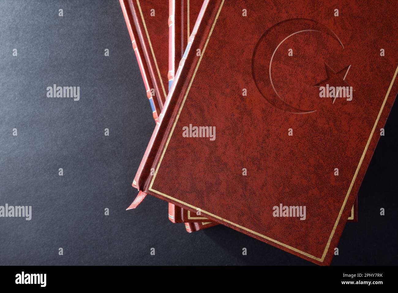 Stack of books with brown leather cover with engraved symbol of islamic ...