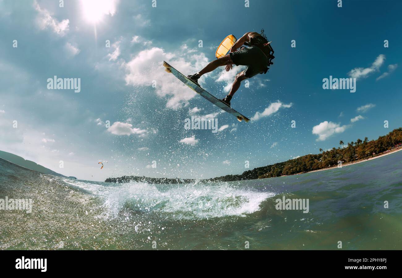 Wakeboarder jumps with kite in open sea. Water sports concept Stock ...