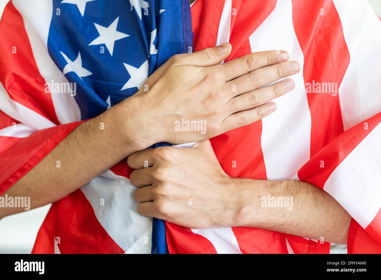 Young man praying by wearing us flag by placing hand on heart - concept ...