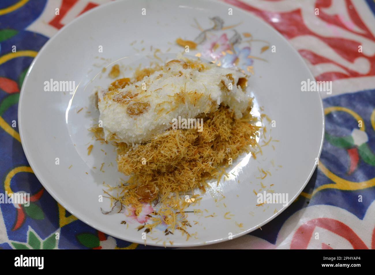 Konafa topped with whipped cream, raisins, walnuts, shredded coconut ...