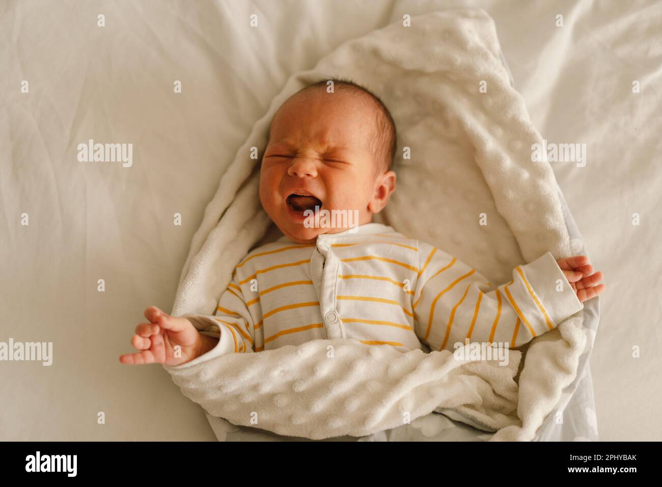Cute emotional newborn little baby boy cry in crib Stock Photo - Alamy