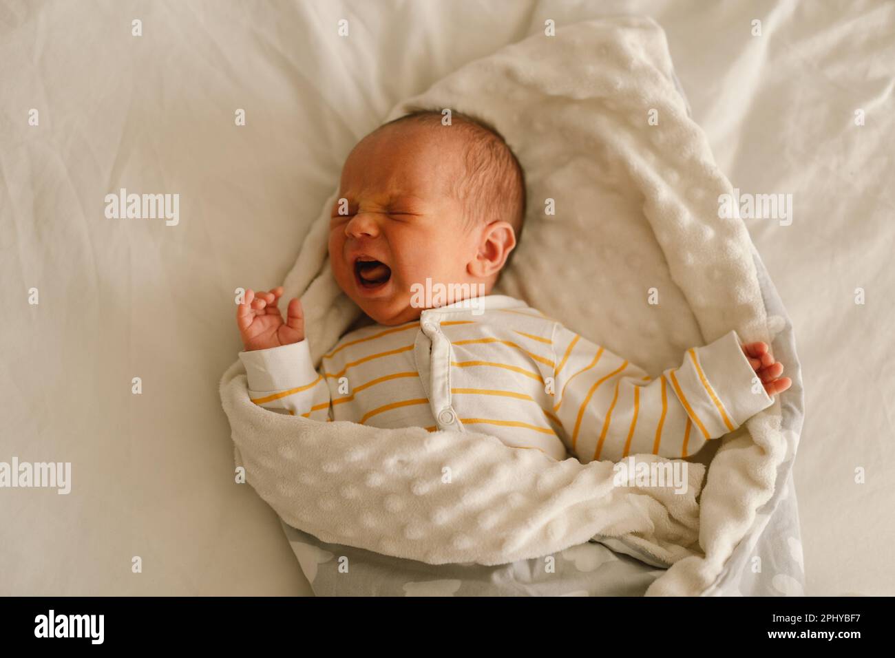 Cute emotional newborn little baby boy cry in crib Stock Photo - Alamy