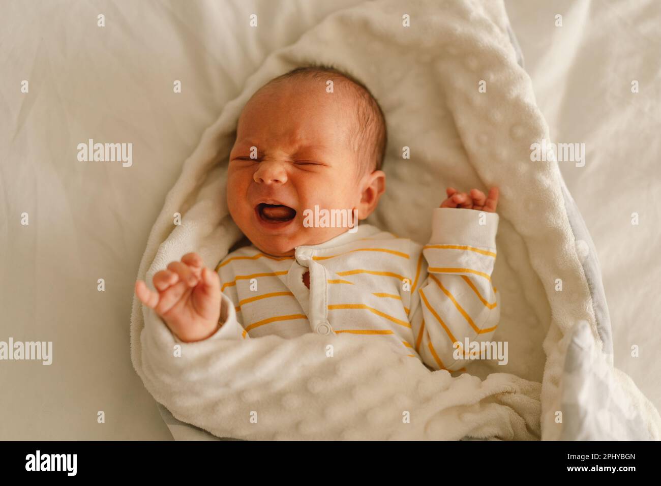 Cute emotional newborn little baby boy cry in crib Stock Photo - Alamy