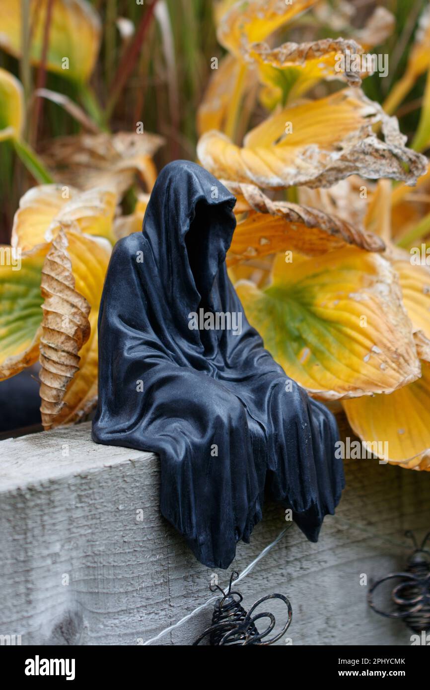 A menacing statue of the Grim Reaper, cloaked in a long, flowing robe ...