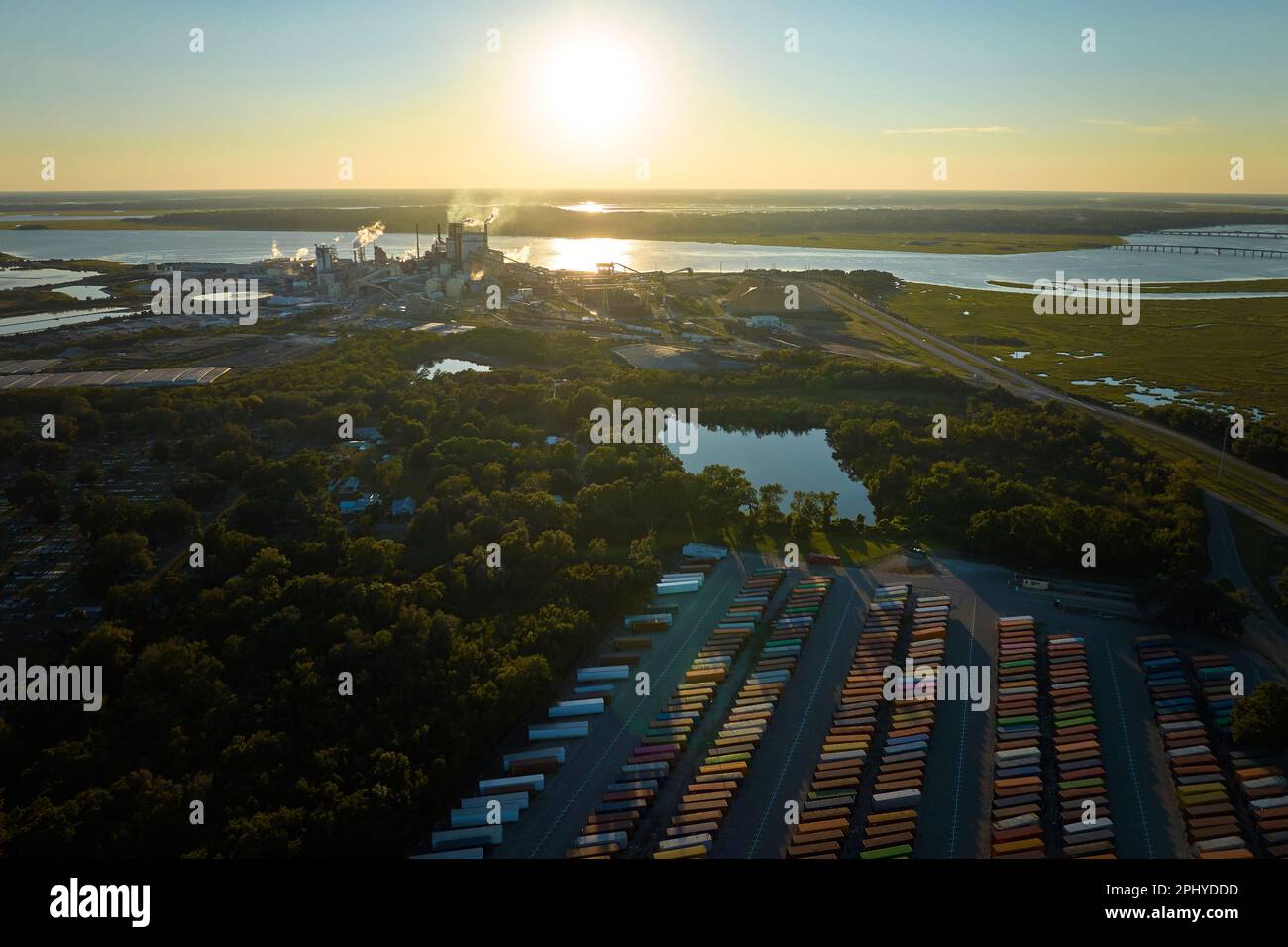 Large cargo container yard with many freight containers and big factory ...