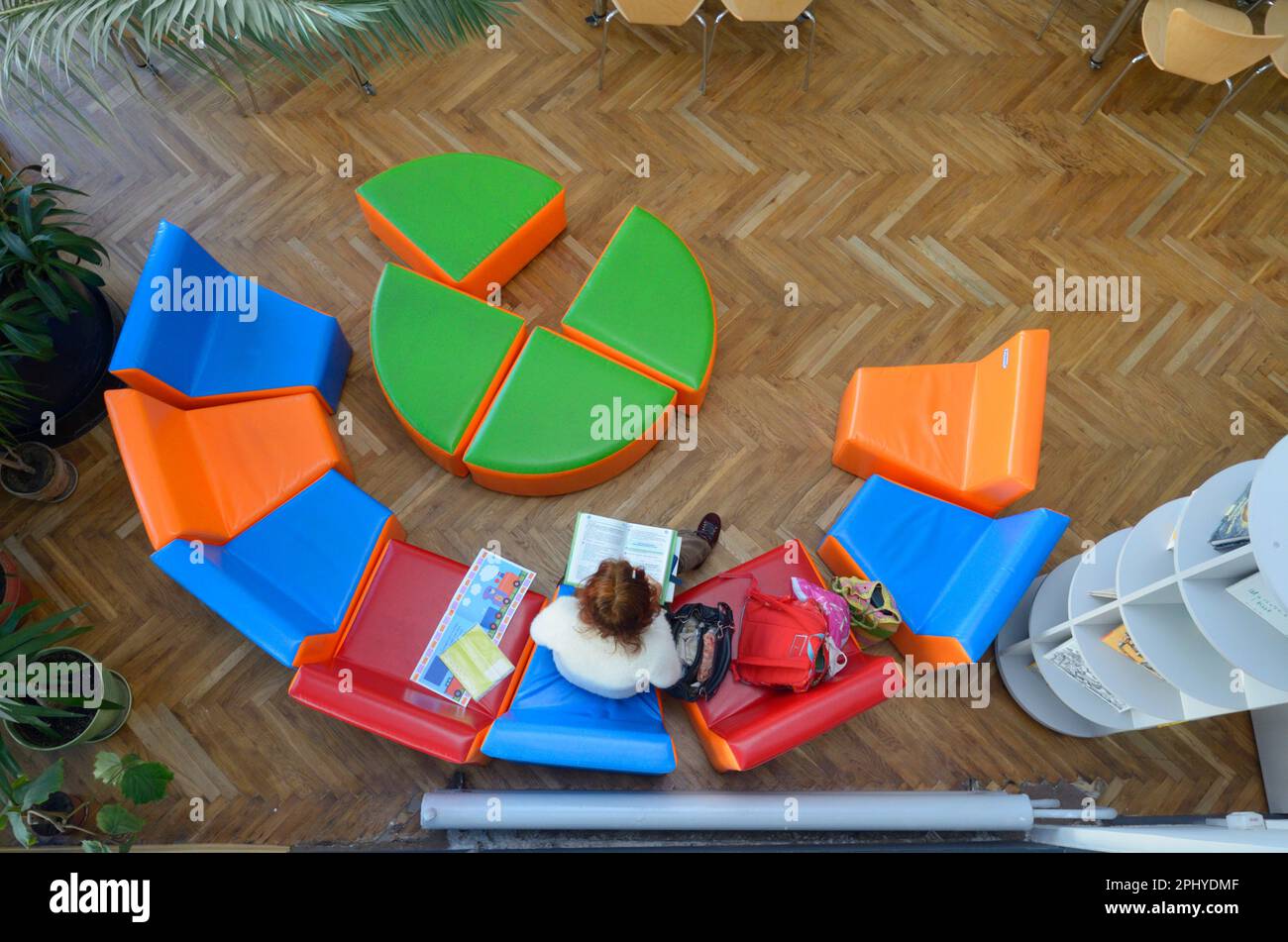Woman reader reading book at the public library, sitting in the reading ...