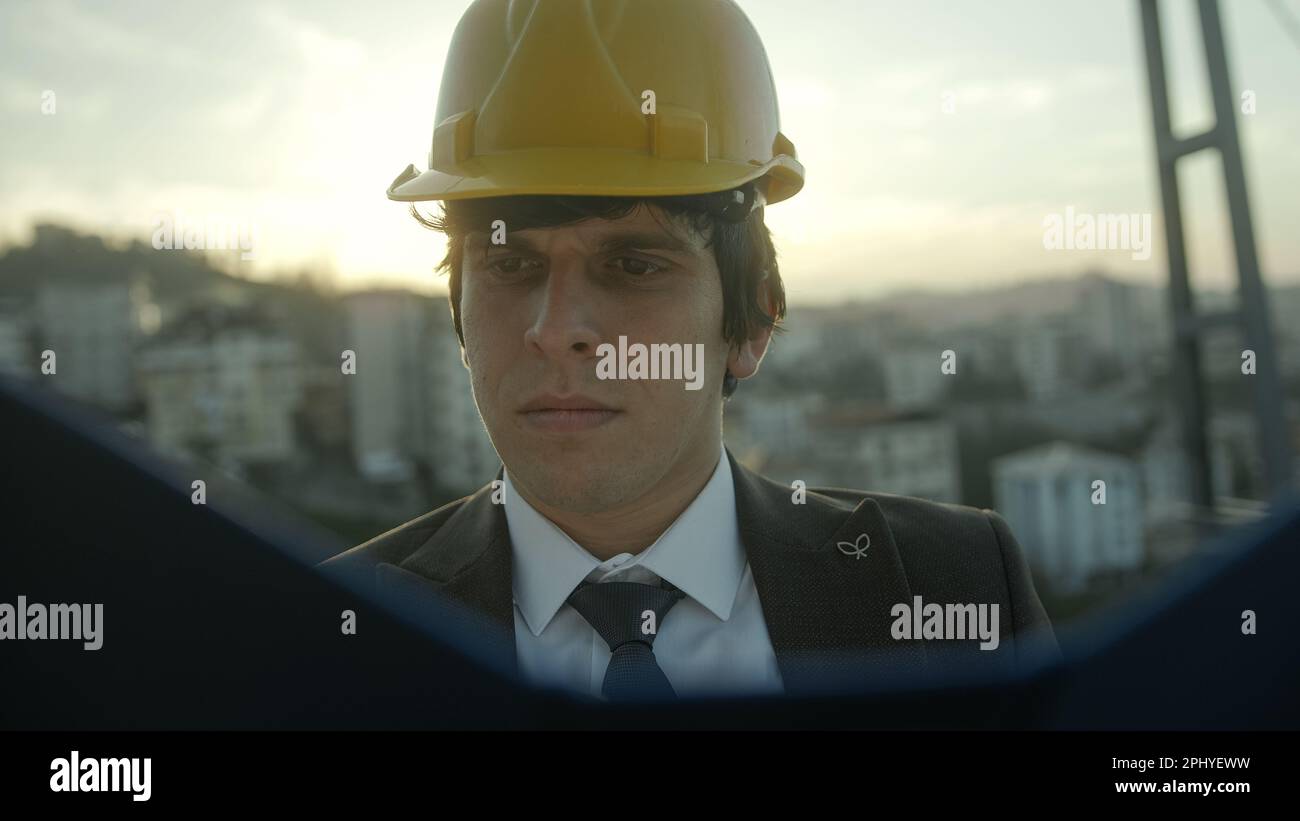 Young Suit-wearing Engineer or Contractor with Hardhat Examining ...