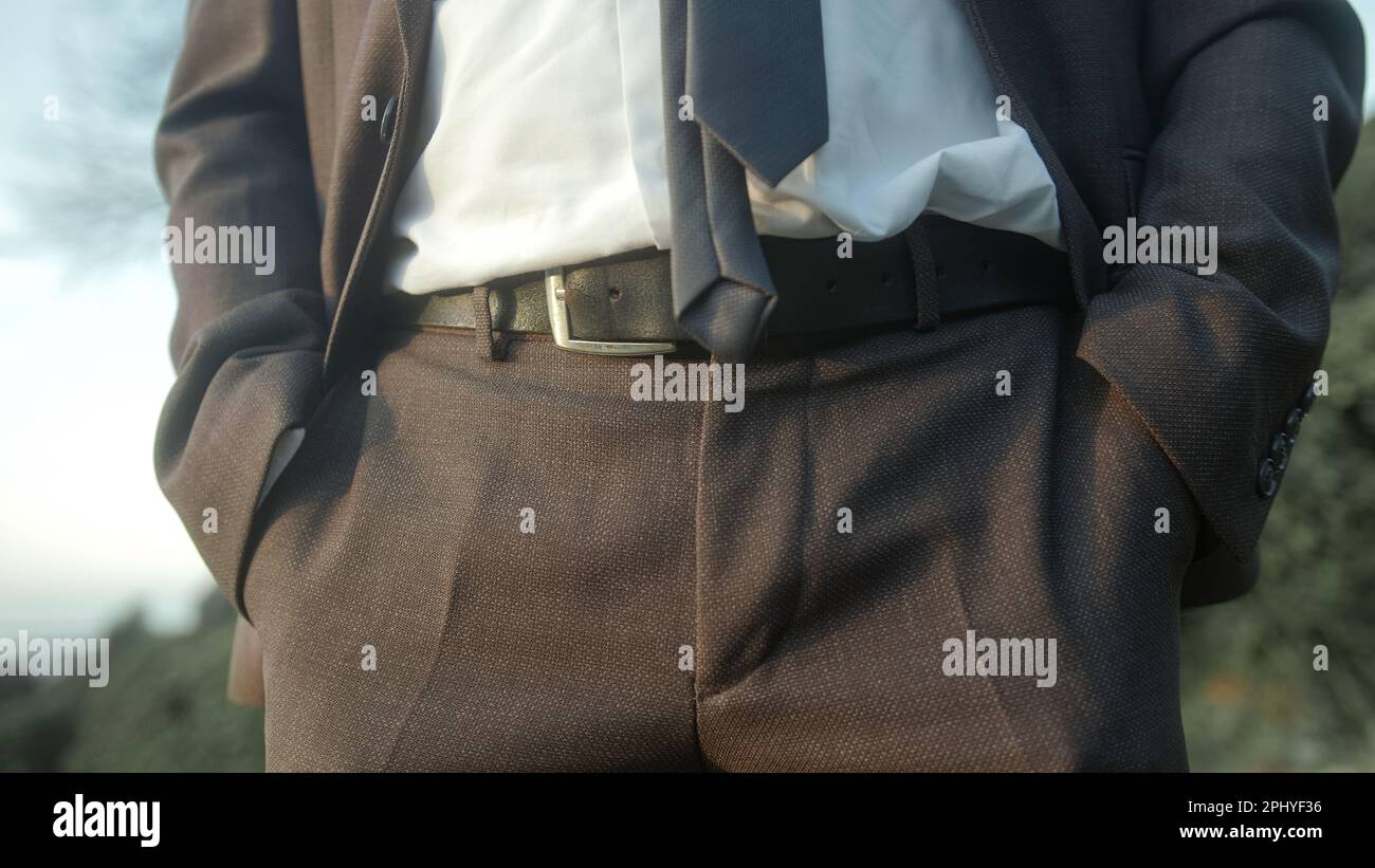 Man in suit puts hands in pocket in extreme close-up shot Stock Photo ...